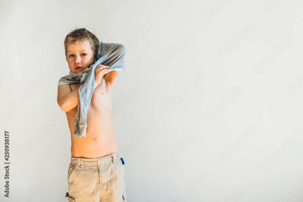 Child Trying To Take Off His Shirt And Undress On His Own Stock Foto child-trying-to-take-off-his-shirt-and-undress-on-his-own-stock-foto