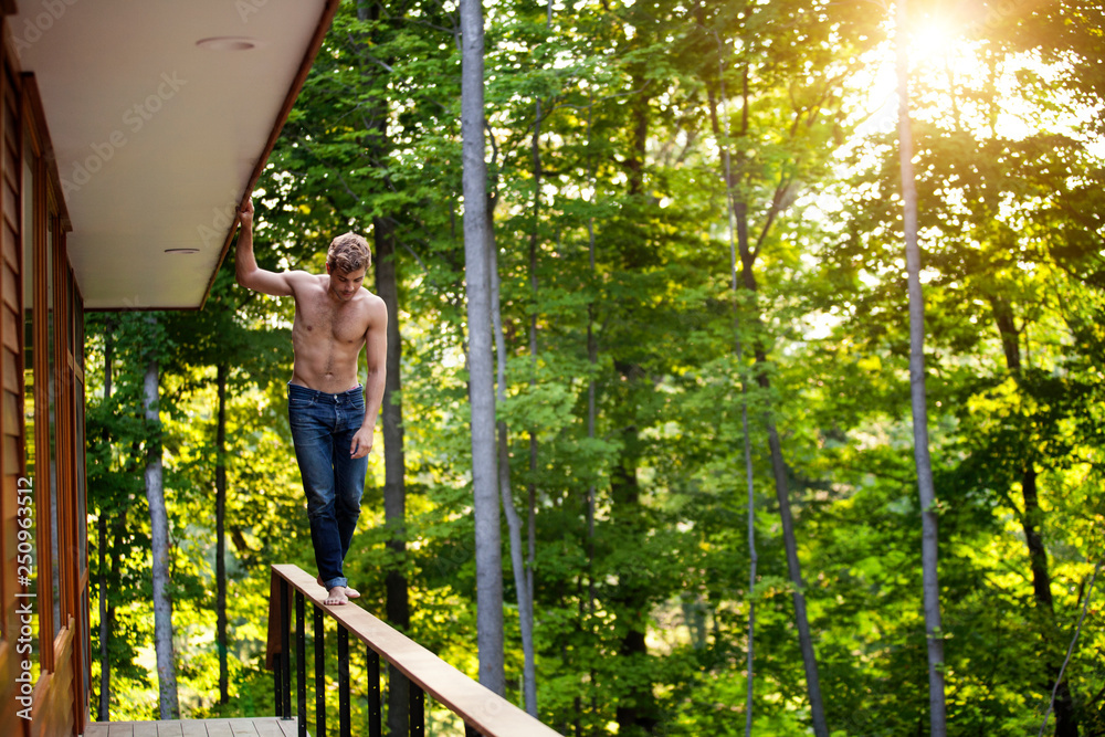 Shirtless young man walking on railing Stock Photo | Adobe Stock