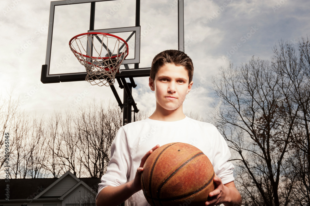 Portrait of teenager (14-15 ) with basketball in front of net Stock ...