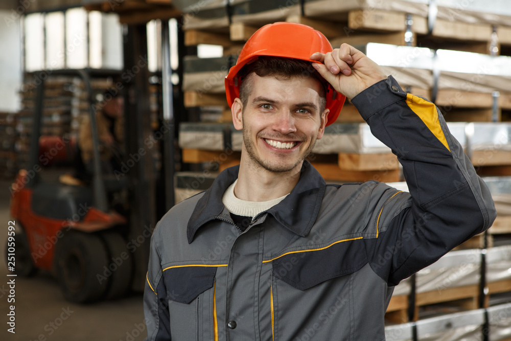 Portrait of happy male worker wearing orange helmet and protective suit ...