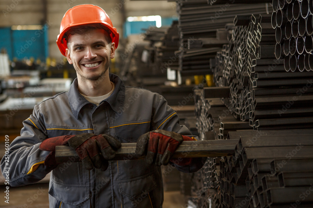 Portrait of handsome happy worker in gray uniform, orange helmet and ...