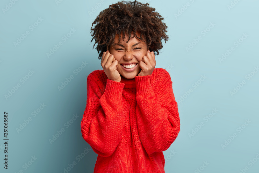 Feeling overjoyed. Positive dark skinned young lady with toothy smile ...