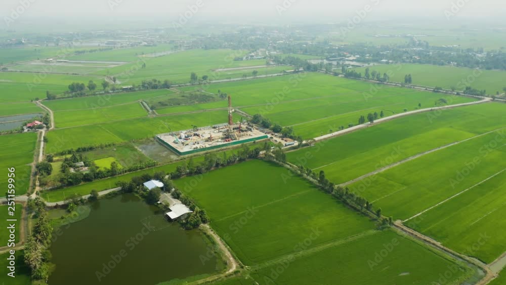 Oil and gas a land rig, onshore drilling rig, in the middle of a rice ...