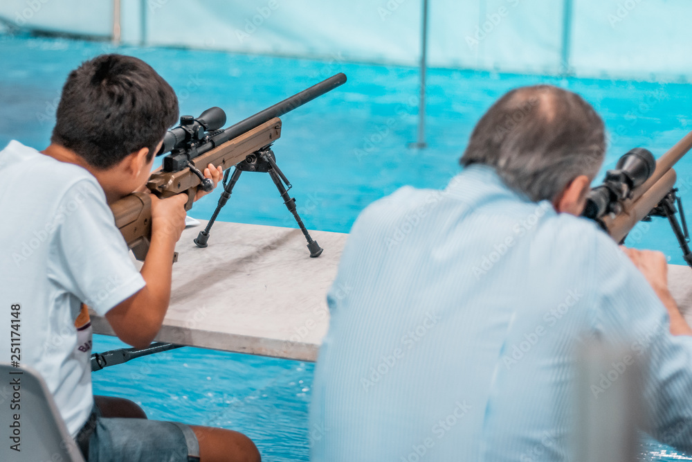 American patriotic gun and weapon culture. Father and son with sniper ...