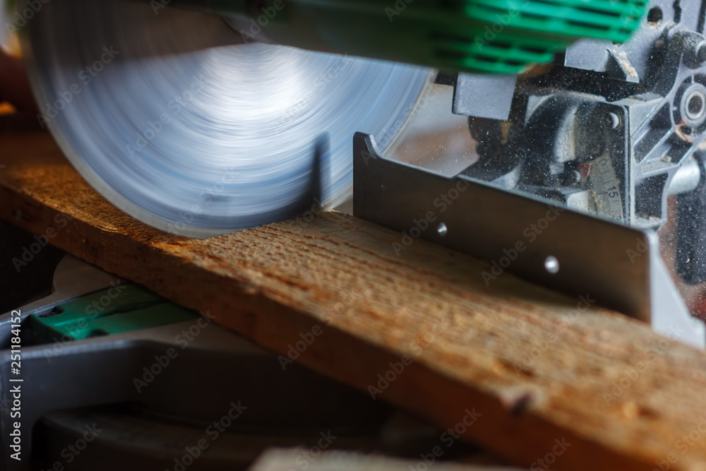 Poster The rotating disc of the circular mitre saw cutting the wood ...
