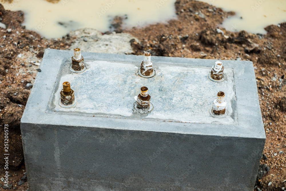 Concrete footing supporting steel beam building under construction ...
