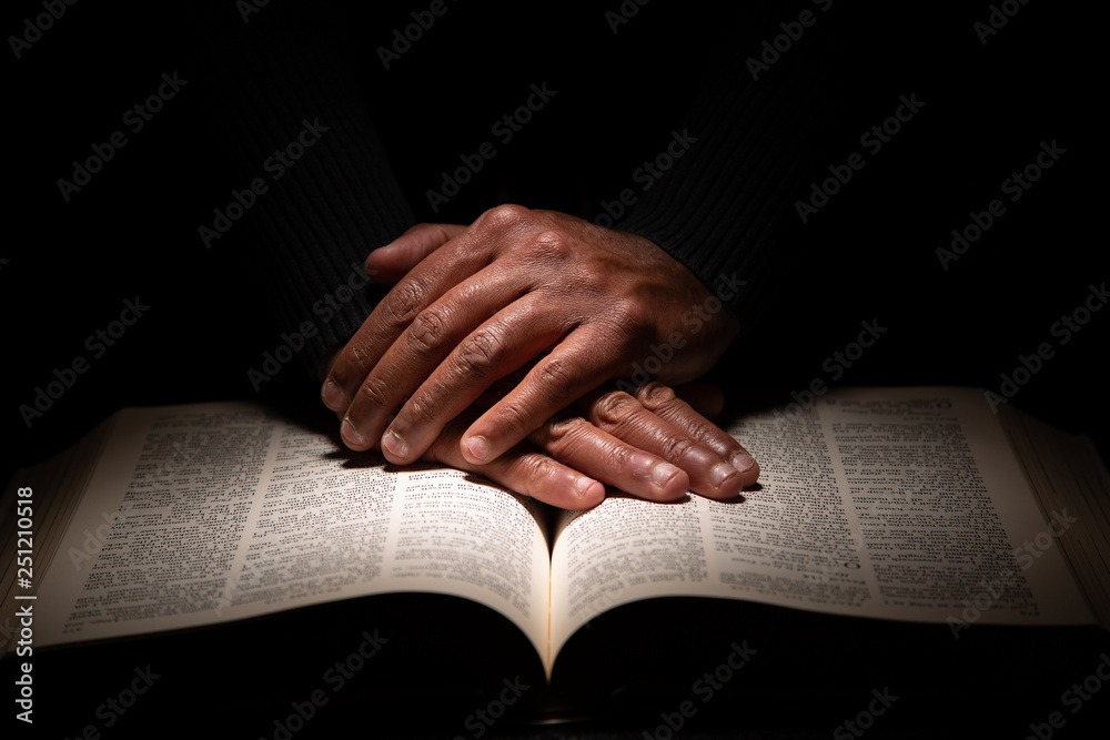African American Man Praying with Hands on Top of the Bible Stock Photo ...
