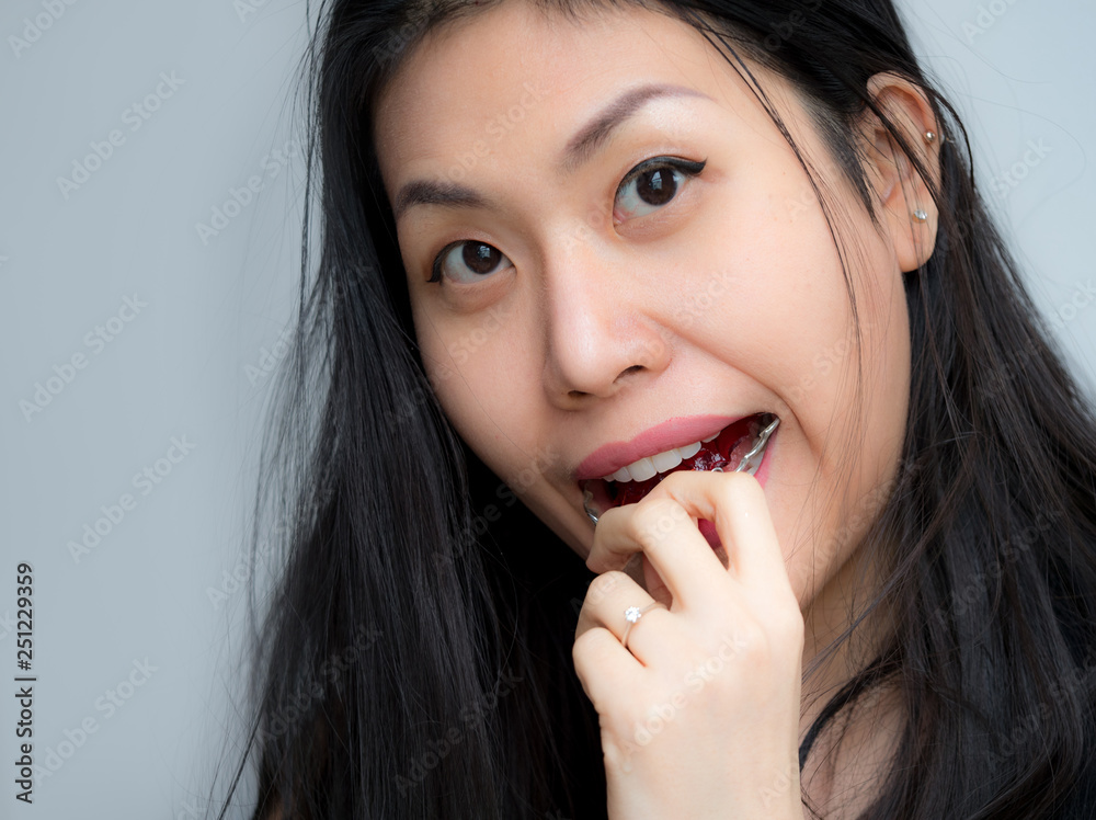Portrait of beautiful Asian patient woman holding orthodontic retainers ...