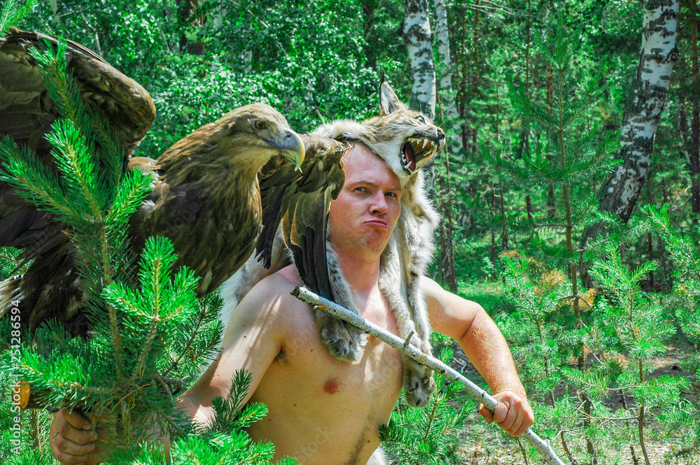 primitive man in the forest hunting with sitting on the arm of an eagle ...