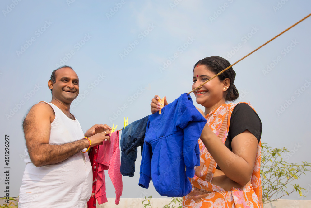 Indian Couple drying clothes on clothesline Stock Photo | Adobe Stock