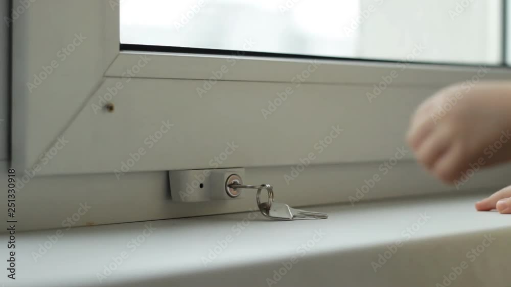 The child is trying to open the pvc window with a hand against the loss ...