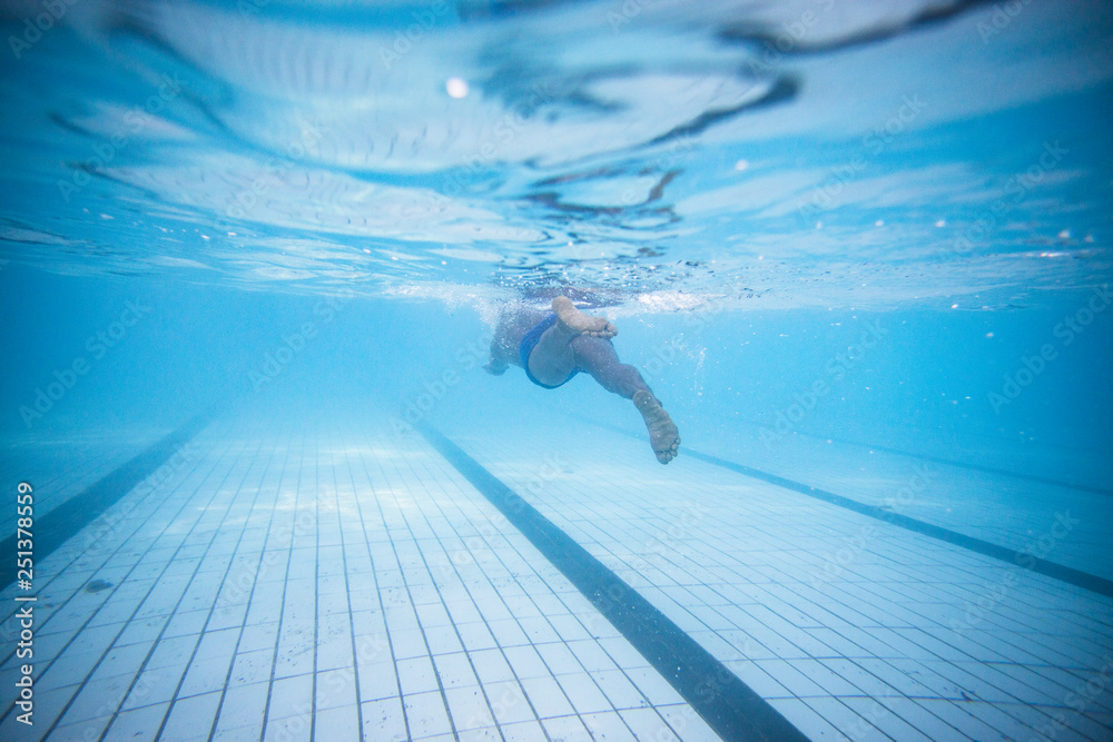 Underwater image of a male swimmer diving into an olympic swimming pool ...