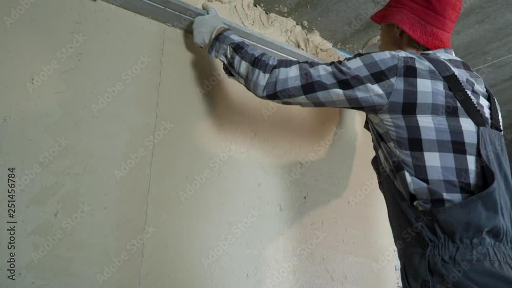 builder leveling plaster on aerated concrete block wall with ...