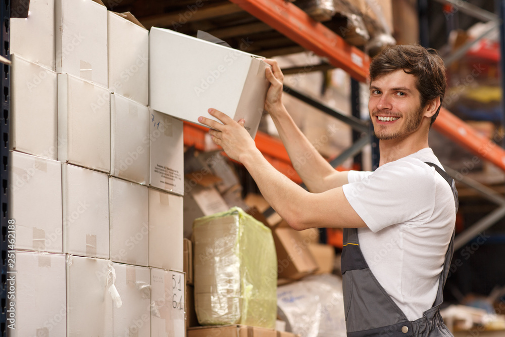 Professional worker checking something while working in warehouse with ...