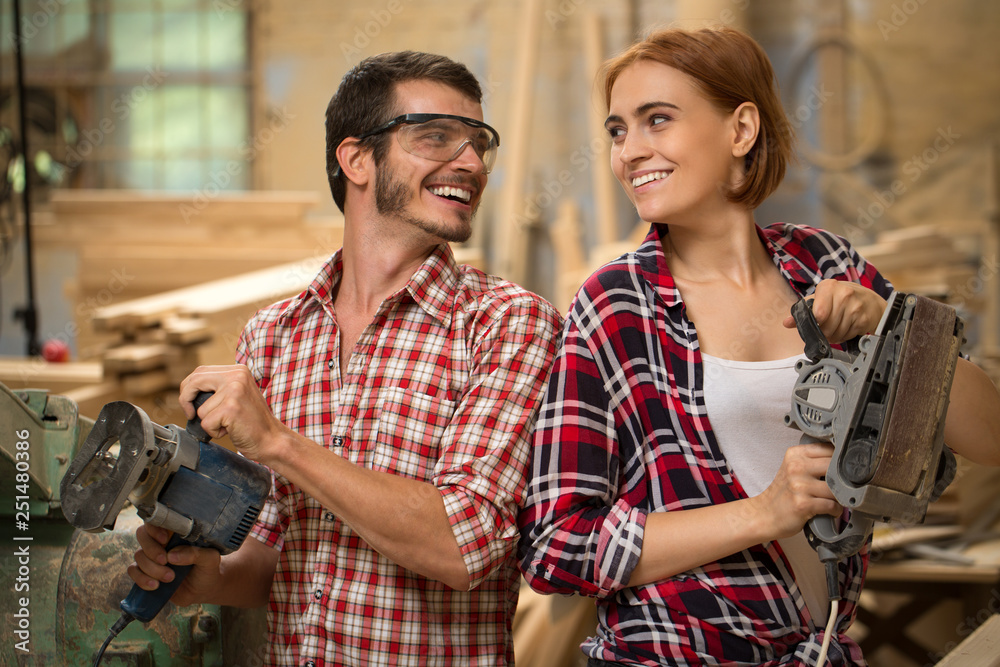 Two happy carpenters looking at each other, smiling and posing. Joiners ...