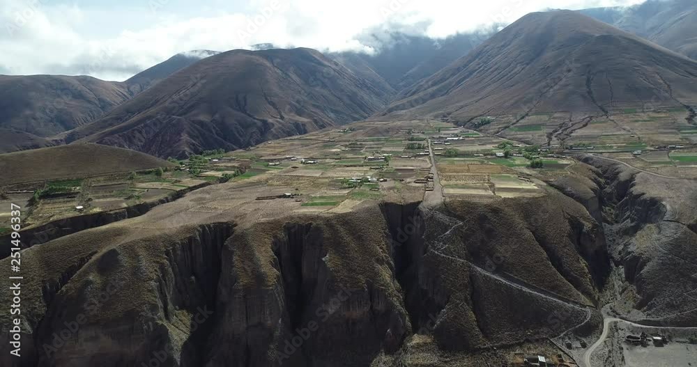 General aerial of farms crops hangging from mountain slope limiting ...
