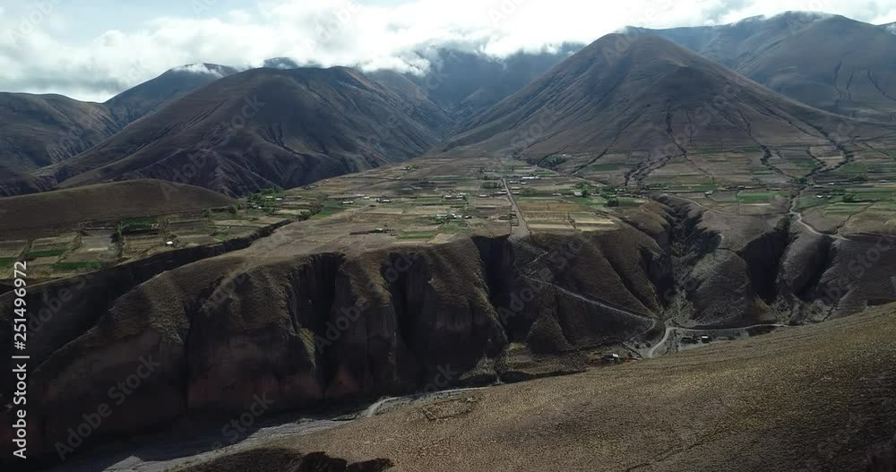 General aerial of farms crops hangging from mountain slope limiting ...