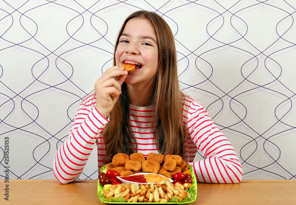 hungry teenage girl eats tasty chicken nuggets Stock Photo | Adobe Stock