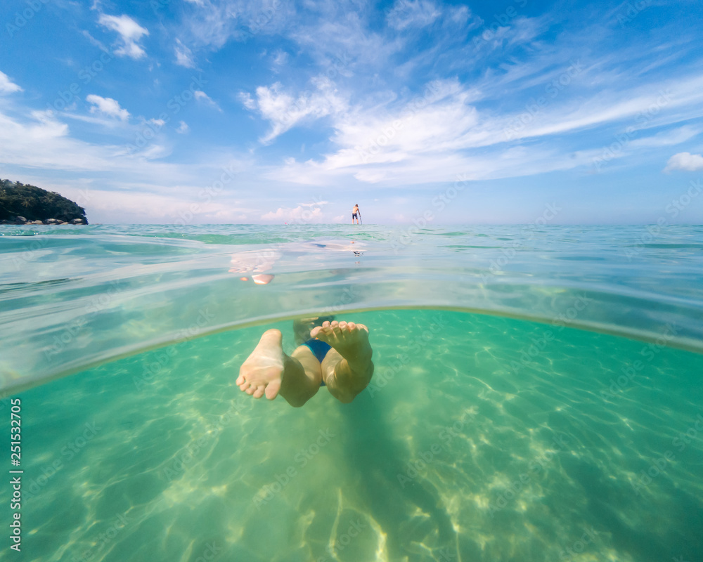 Foto de Underwater photo of woman swimming in ocean. View from the back ...