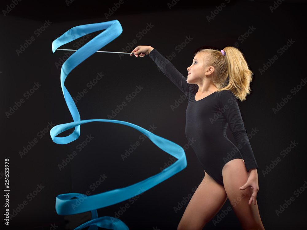 Young beautiful white caucasian girl gymnast doing gymnastic exercise ...