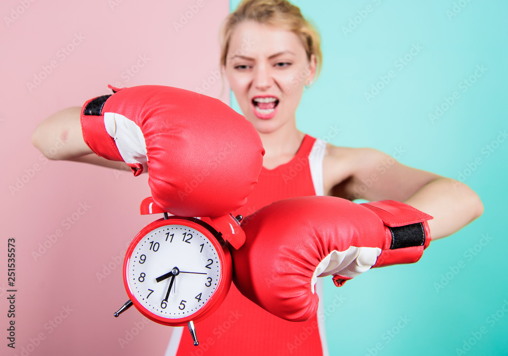 Its time for boxing training. Emotional woman holding clock in boxing ...