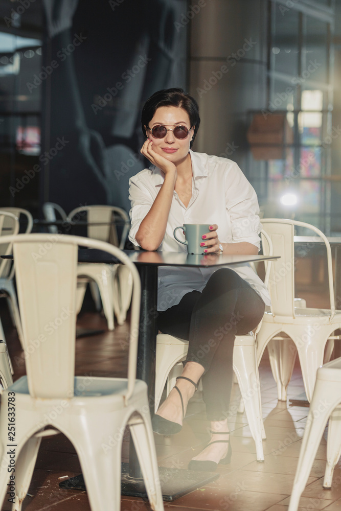 Beautiful European caucasian woman sitting in an outdoor cafe with ...
