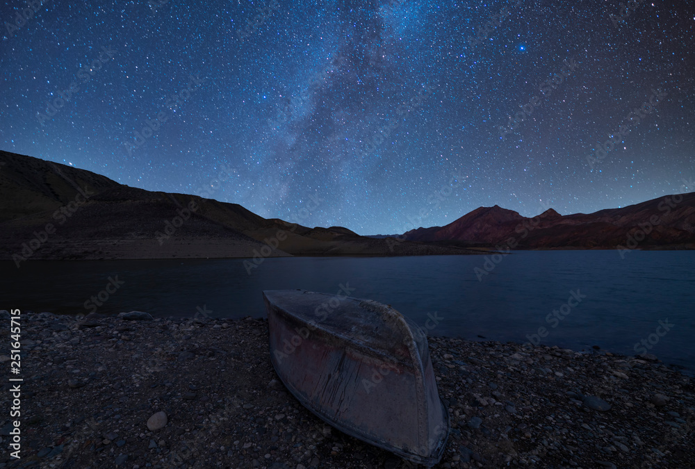 Beautiful night landscape, small boat, starry night over the lake and ...