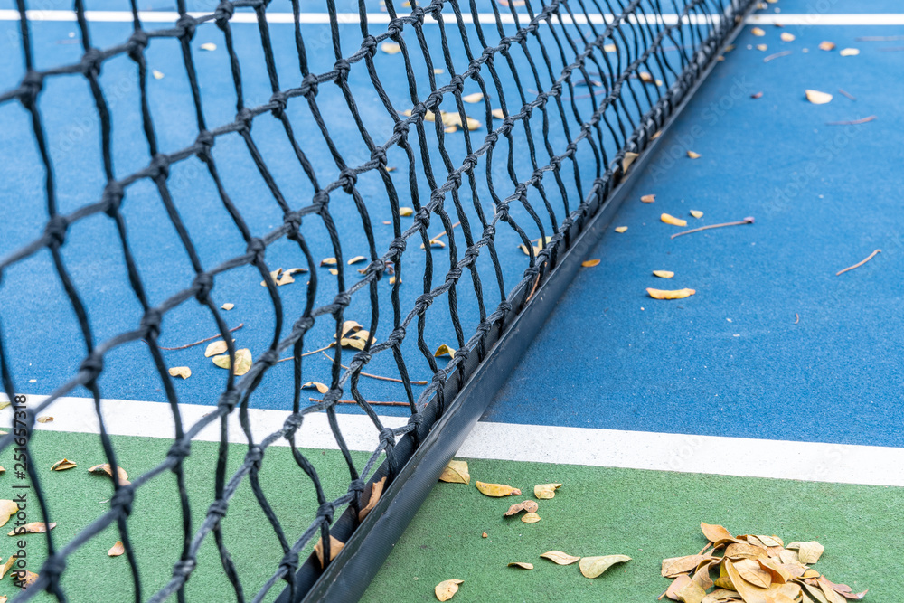 Black woven net on hardcourt surface tennis court in game/sports ...