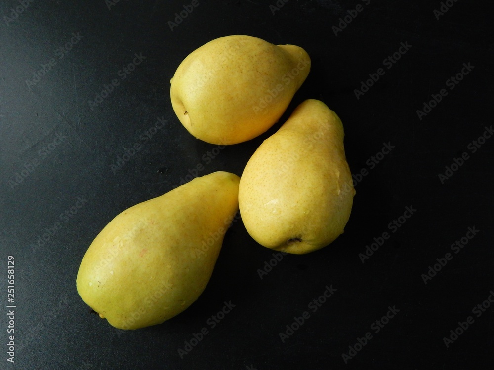 Ripe pears on black background as a low-calorie source of folic and ...