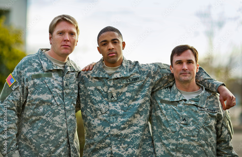Portrait of three US Army soldiers with their arms around each other ...
