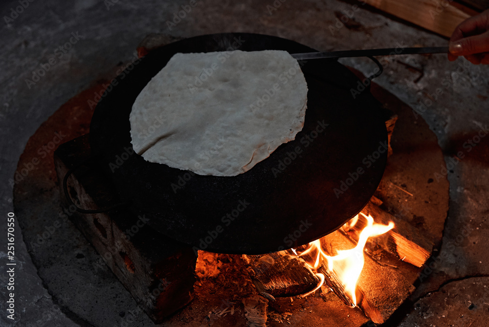 Pita bread baking on a saj or tava on fire, close-up Stock Photo ...