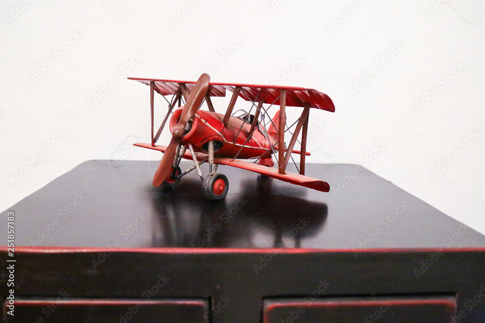 model of a red biplane aircraft with propeller driven engine on a black ...