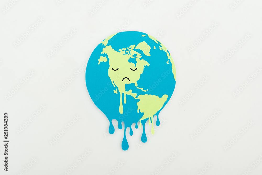 melting paper cut globe with sad face expression on grey background ...