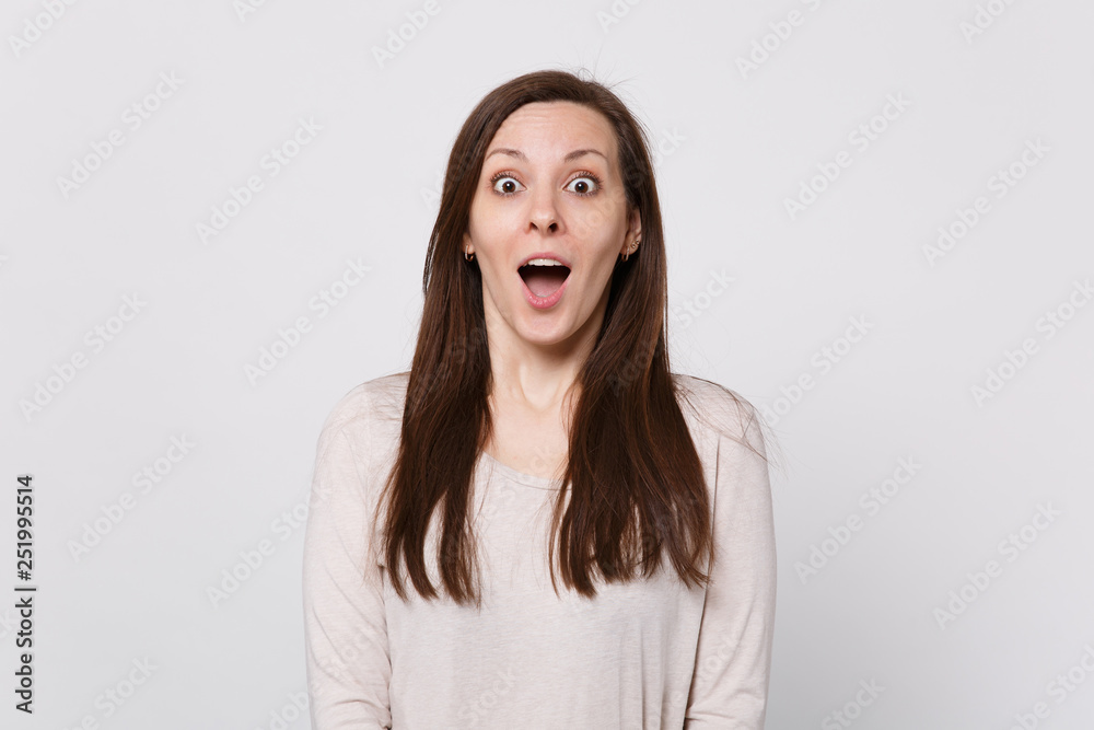 Portrait of excited surprised young woman in light clothes looking ...