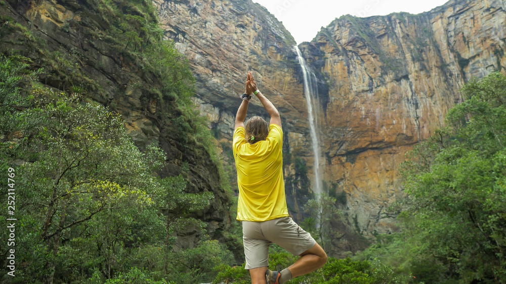 Man climbing hill walking stick in hand and backpack, Waterfall of ...