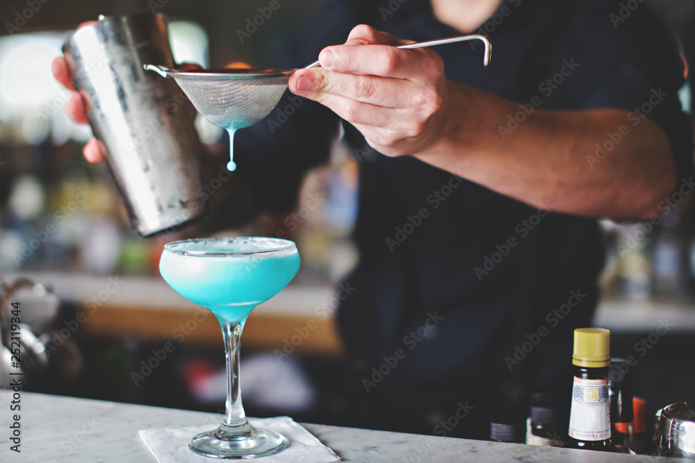 bartender pouring a cocktail into glass Stock Photo | Adobe Stock