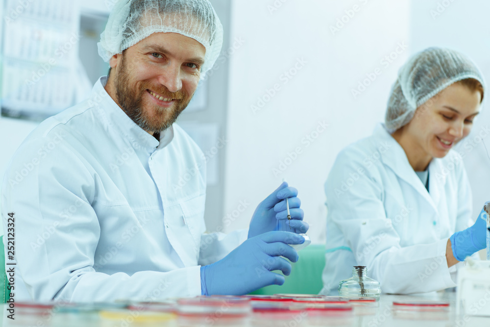 Happy two smiling scientists making research with samples. Man and ...