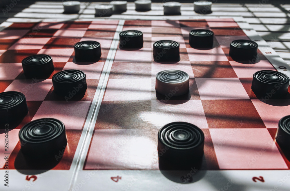 Checkers on a paper chessboard with pink and red cells. Difficult ...