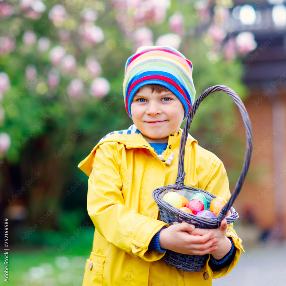 Cute adorable little kid boy making an egg hunt on Easter. Happy child ...