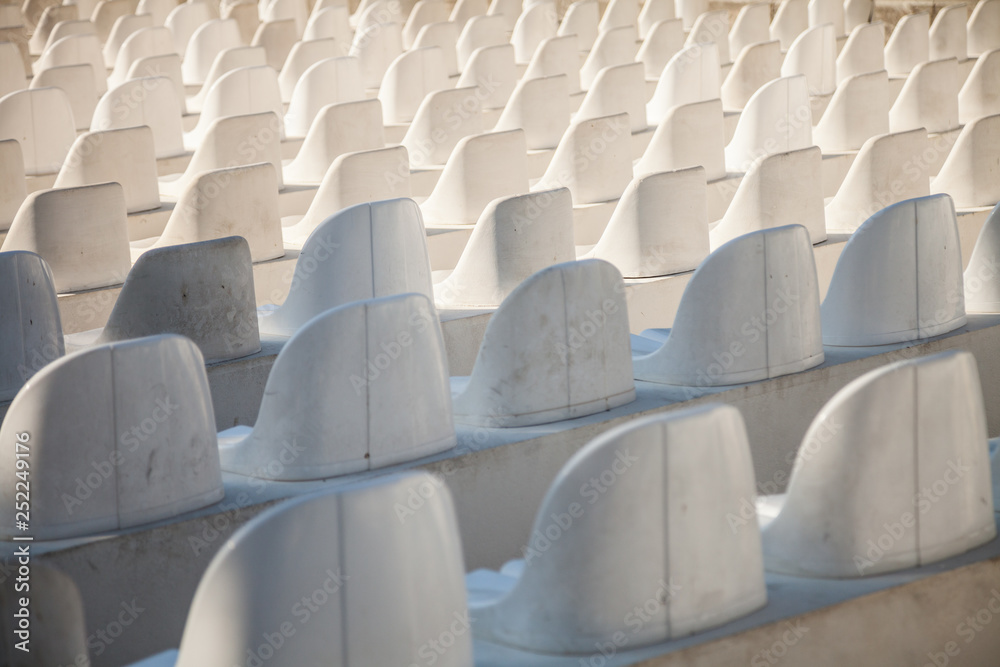 Backside rows of white chairs in the amphitheater with different levels ...