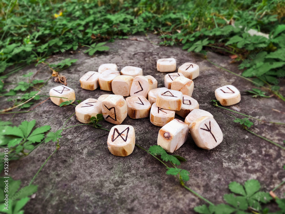 A stack of wooden runes at forest. Wooden runes lie on a rock ...