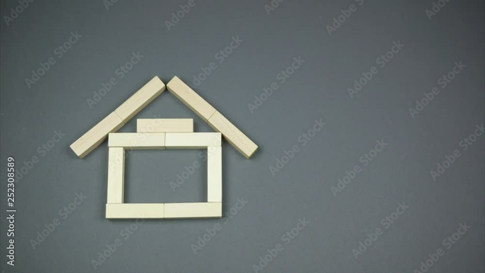 Simple shape house of wooden blocks. Grey background. Stop motion ...