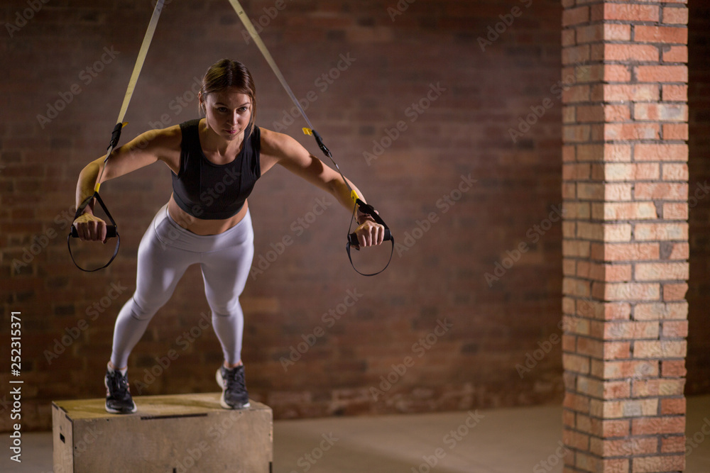 TRX Push ups performing by caucasian athletic woman, TRX Suspension ...