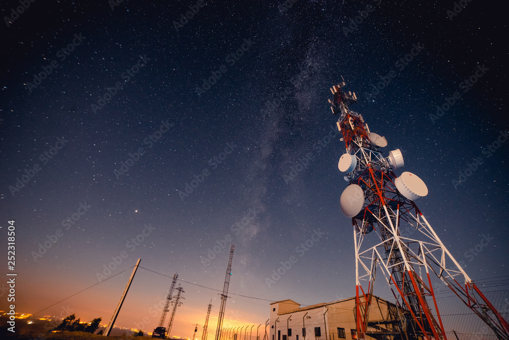 From below tall modern radio tower located against majestic starry sky ...
