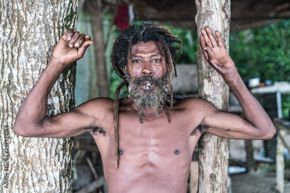 African American Bearded Male With Dreadlocks And Upped Hands Smoking