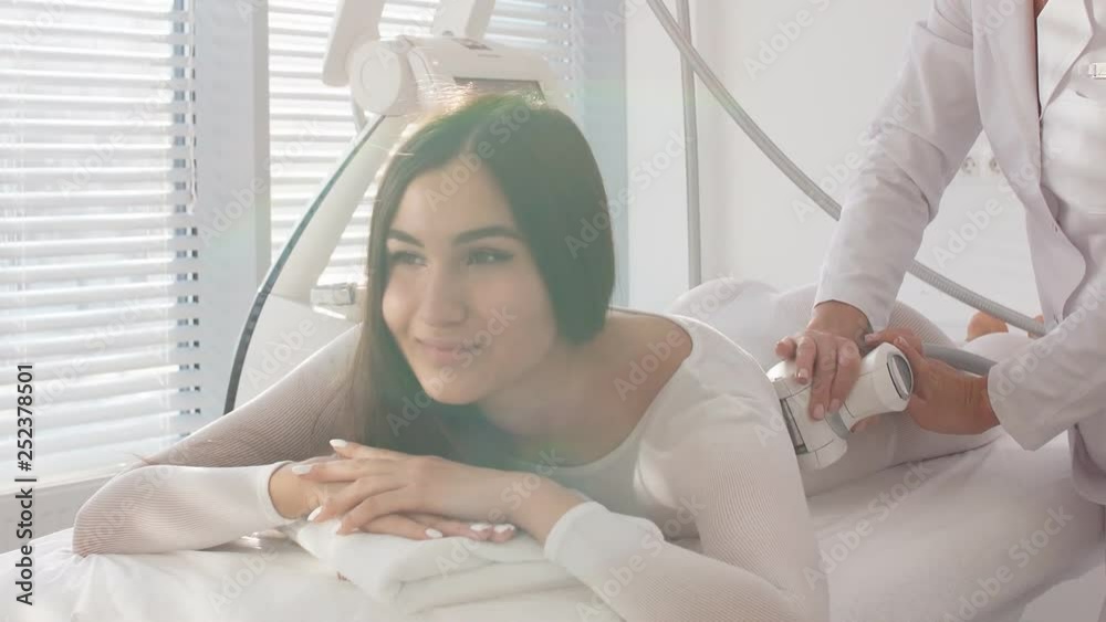 Vídeo do Stock: Portrait of brunette woman dressed in white LPG slimming bodysuit, looking at ...