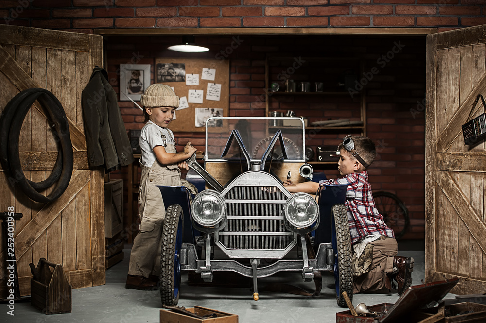 Boys-mechanic with tools in the car in the garage Stock Photo | Adobe Stock