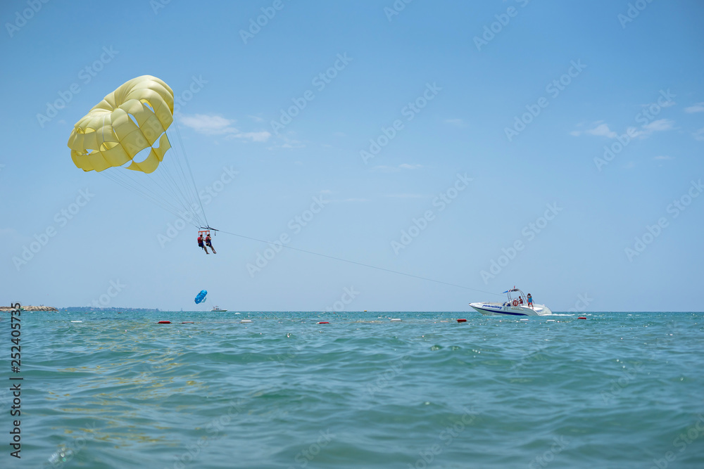 Happy couple Parasailing on Tropical Beach in summer. Couple under ...