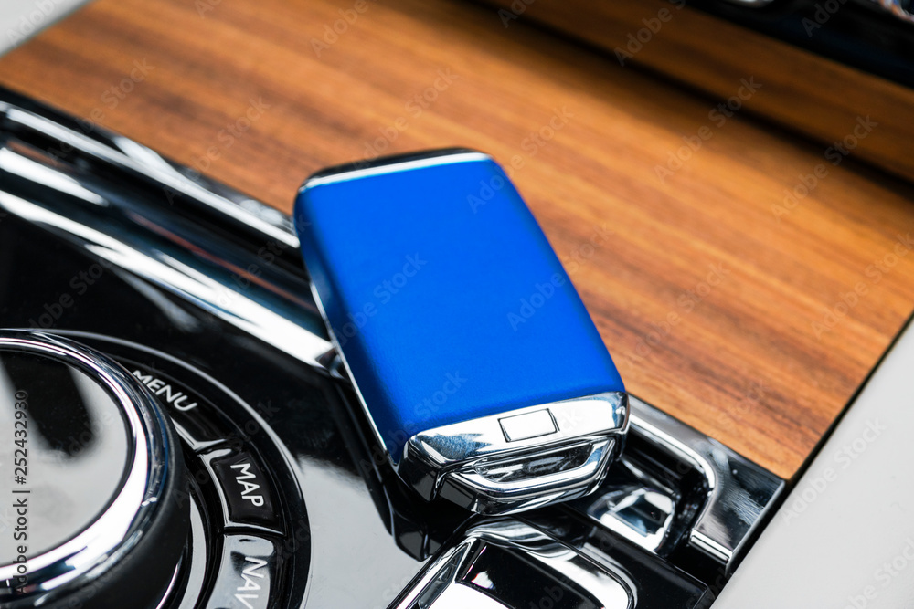 Closeup inside vehicle of wireless blue leather key ignition on natural ...