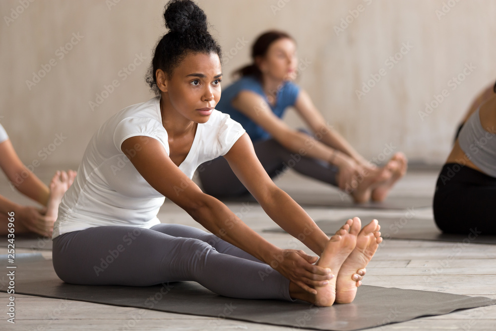 Black woman and group of people, Seated forward bend pose Stock Photo ...